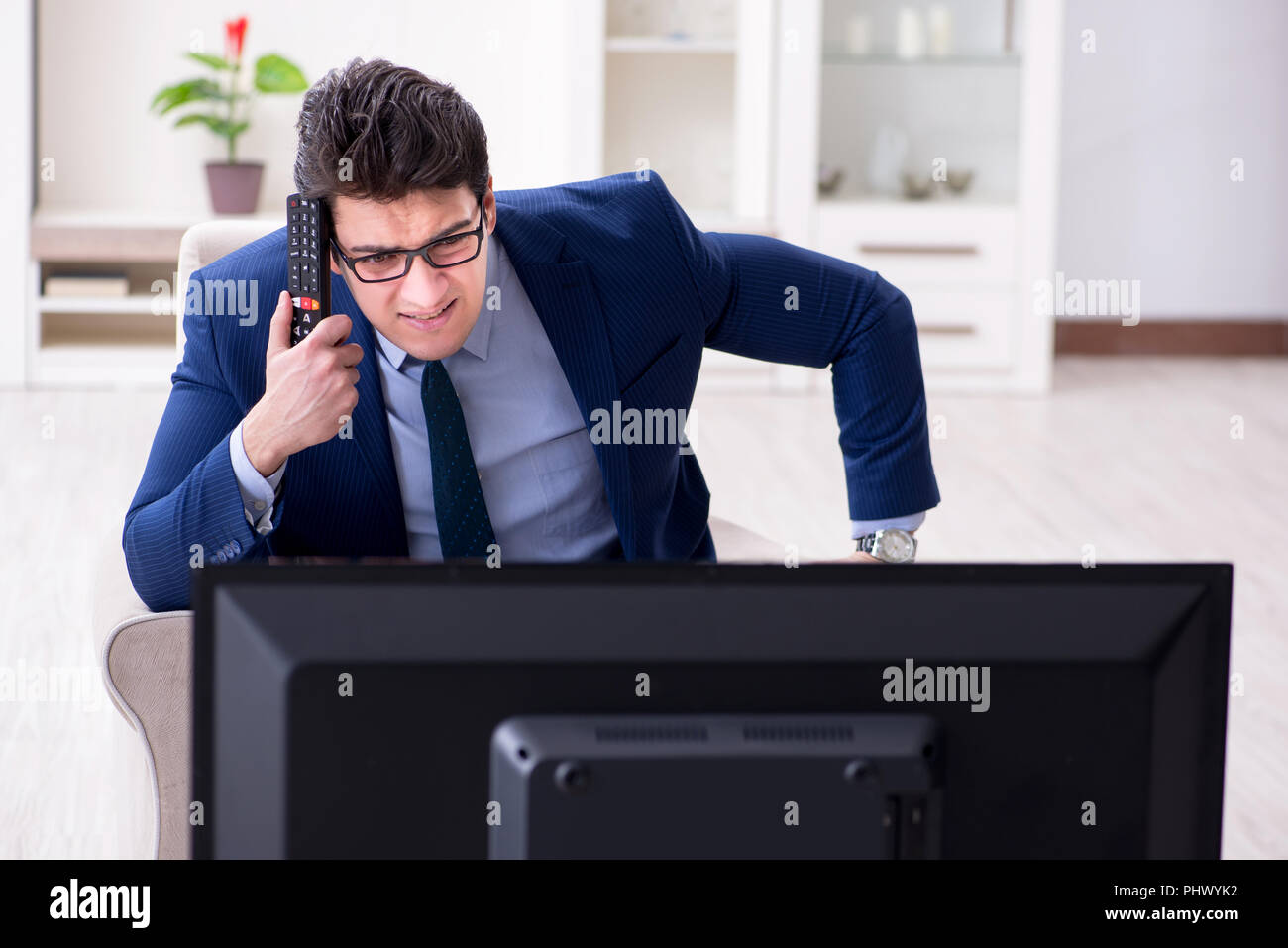 Businessman watching tv in the office Stock Photo - Alamy