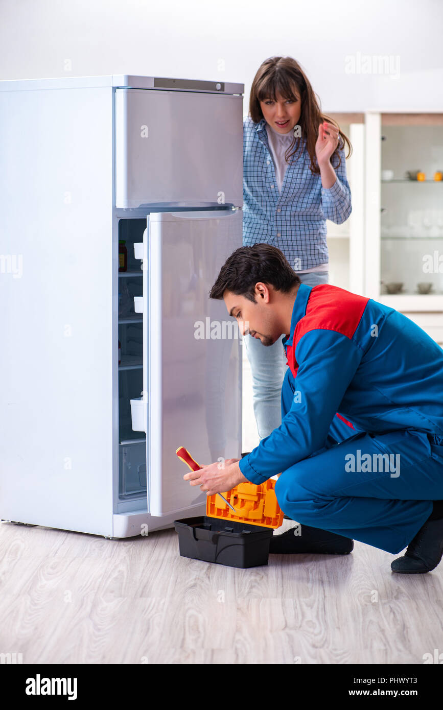 Man repairing fridge with customer Stock Photo - Alamy