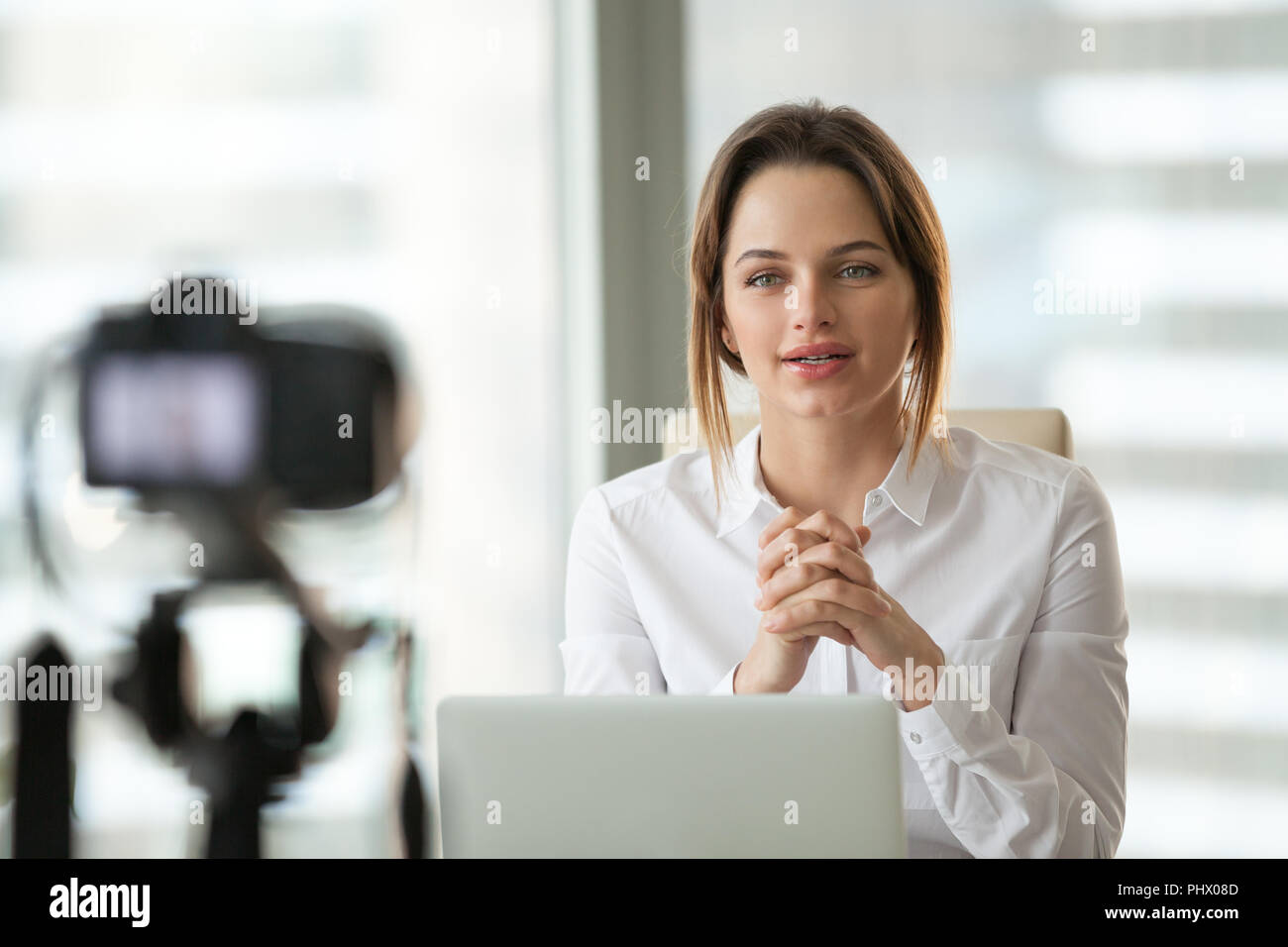 Successful businesswoman vlogger or coach talking to camera film Stock ...