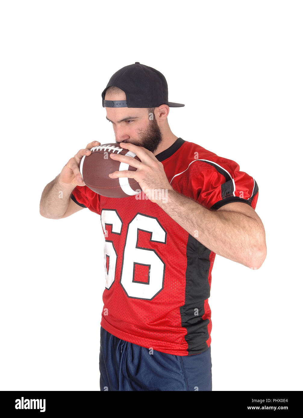 Football player holding his ball on his mouth thinking Stock Photo - Alamy