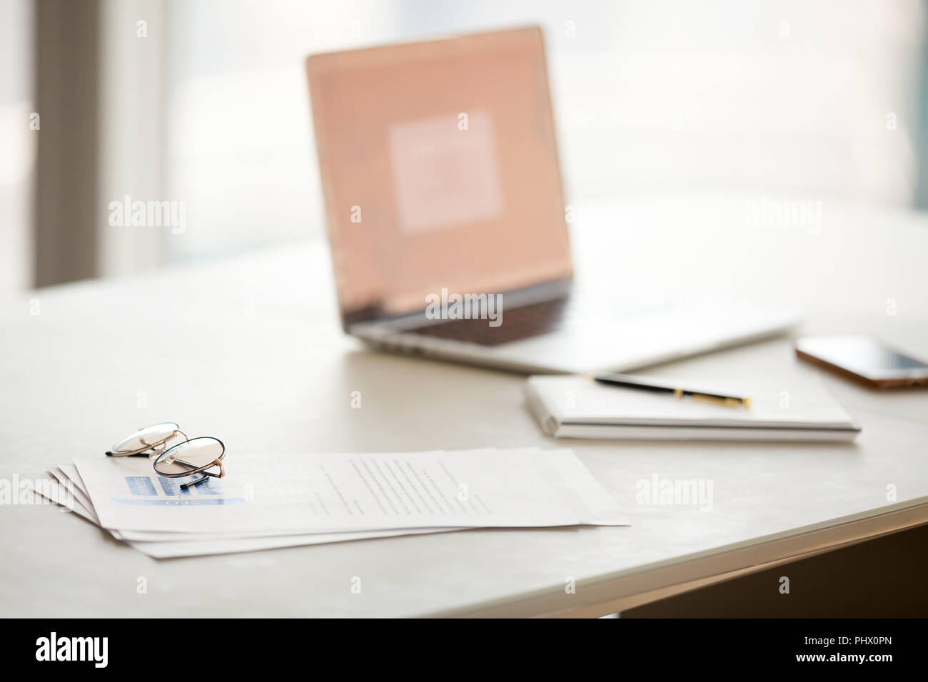 Office table with laptop, documents and glasses for reading conc Stock ...