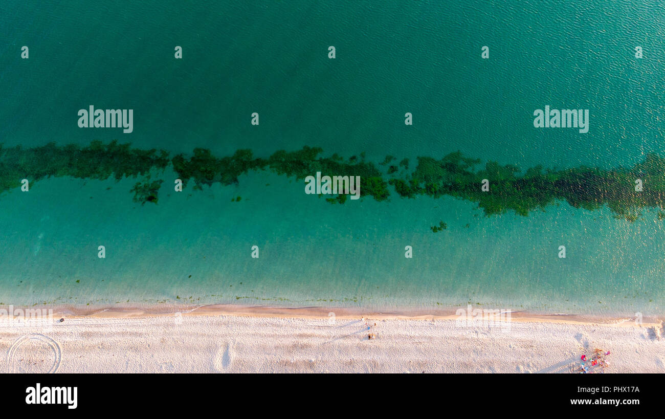 Aerial view of sea waves crashing on beach without people. sun glare on ...
