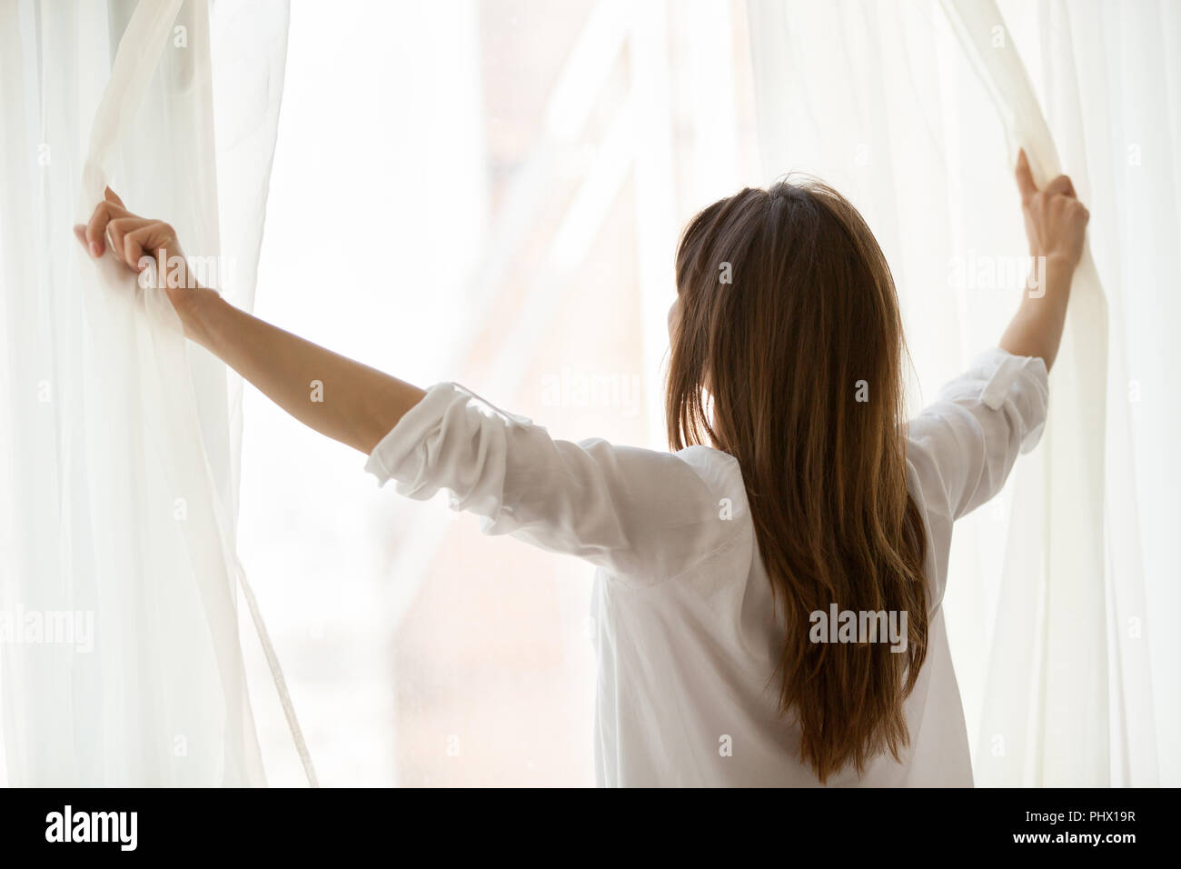 Positive woman looking curtains hi-res stock photography and images - Alamy
