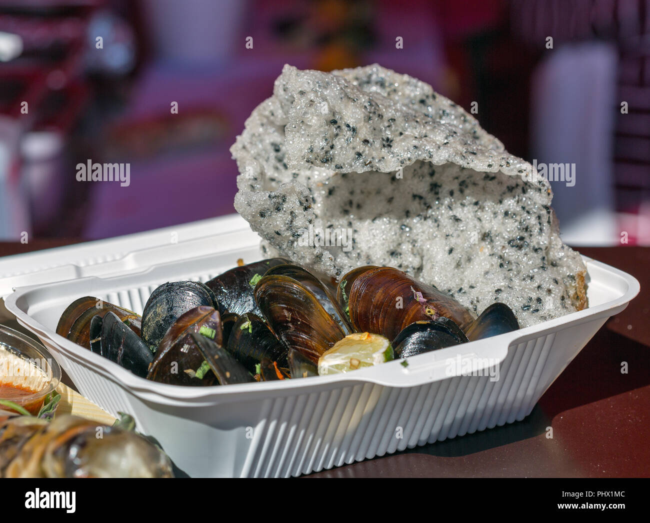 Fast food cooked mussels with rice chips with black sesame closeup ...