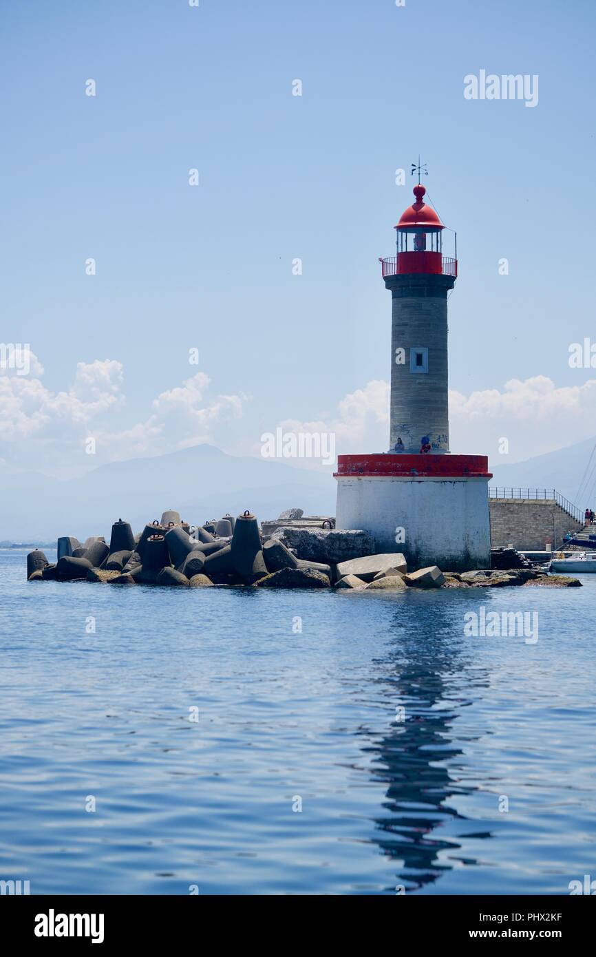 Red lighthouse seen from the ocean Stock Photo - Alamy