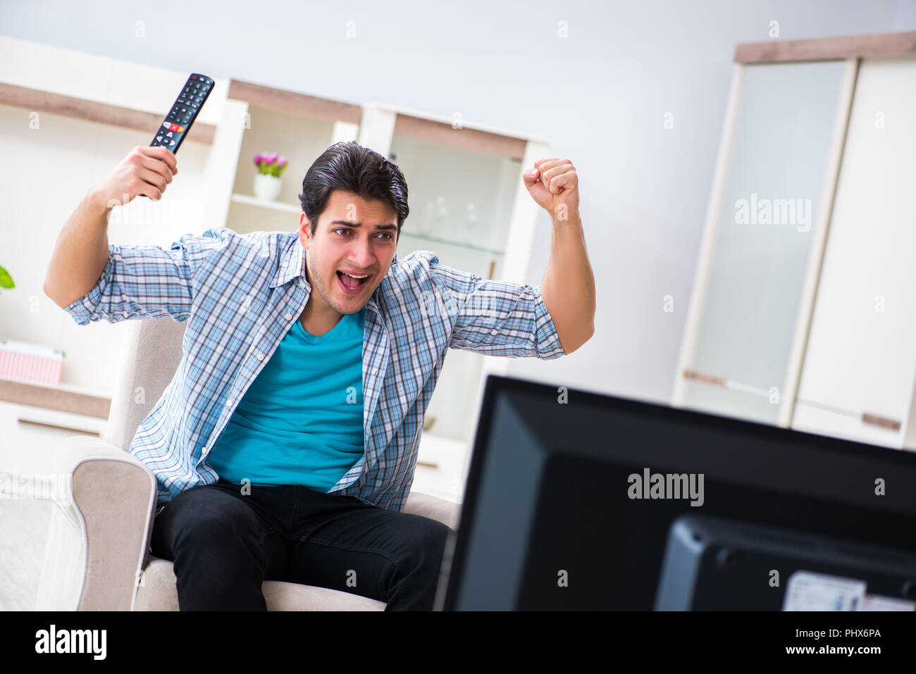 Man watching tv at home Stock Photo - Alamy