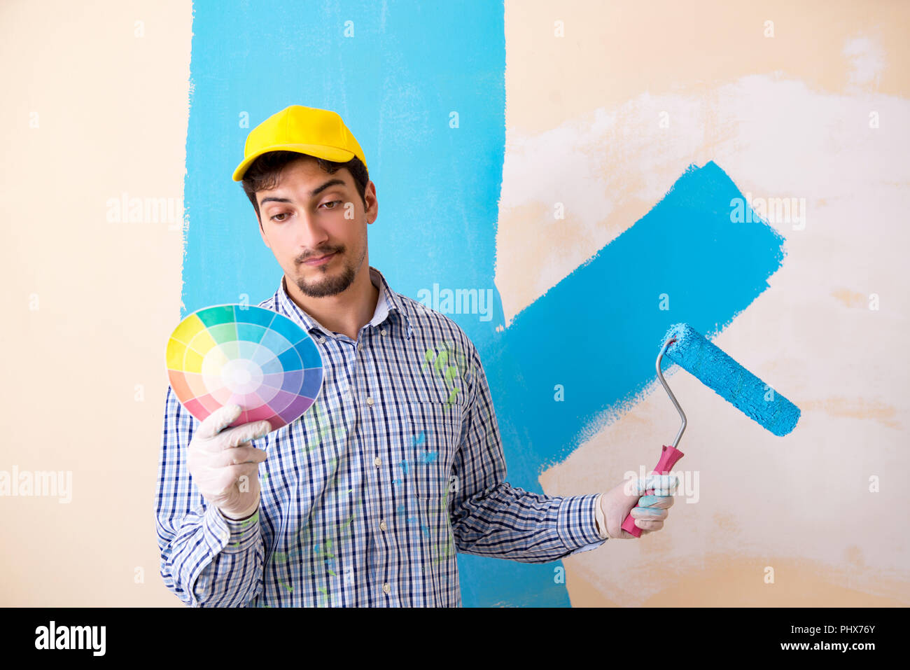 Painter man painting the wall at home Stock Photo - Alamy