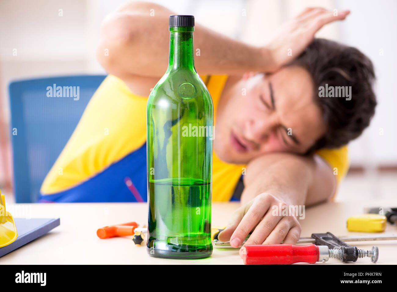 Drunk engineer working in the workshop Stock Photo - Alamy