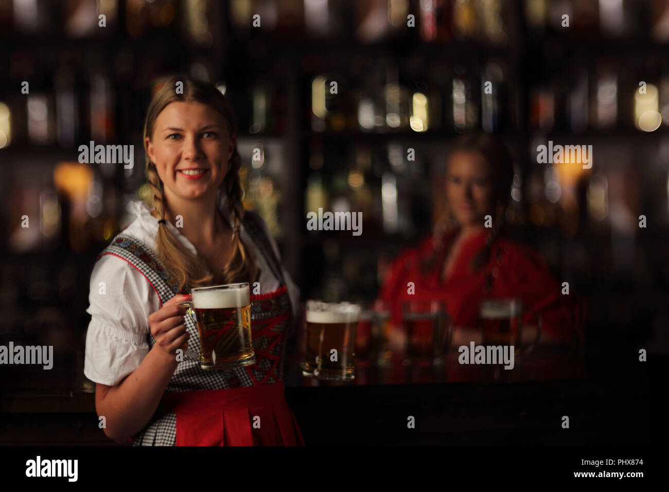 Pretty oktoberfest blonde woman holding beer mugs in bar Stock Photo ...