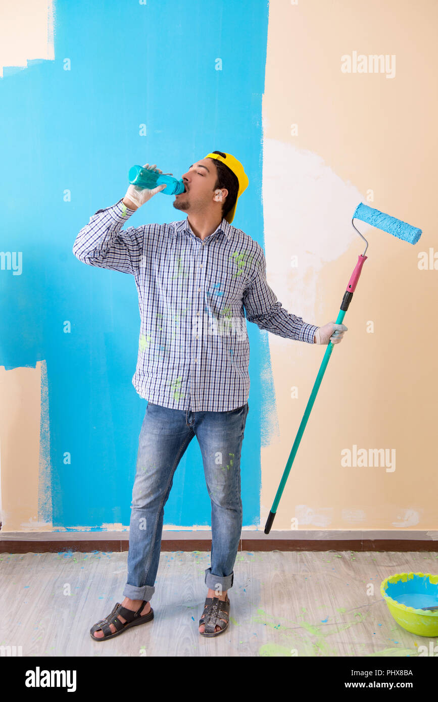 Painter man painting the wall at home Stock Photo - Alamy