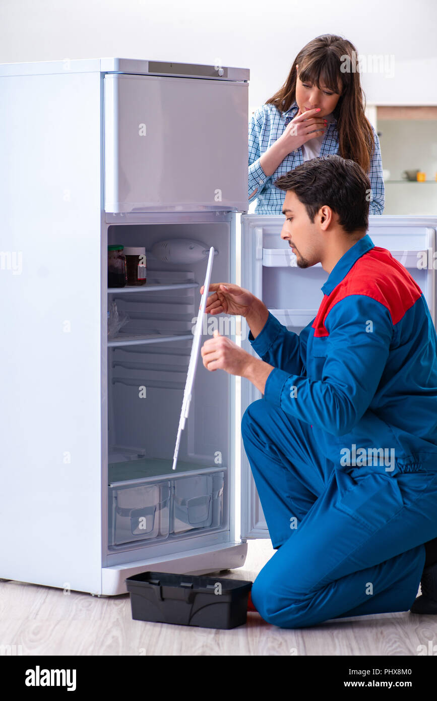 Man repairing fridge with customer Stock Photo - Alamy