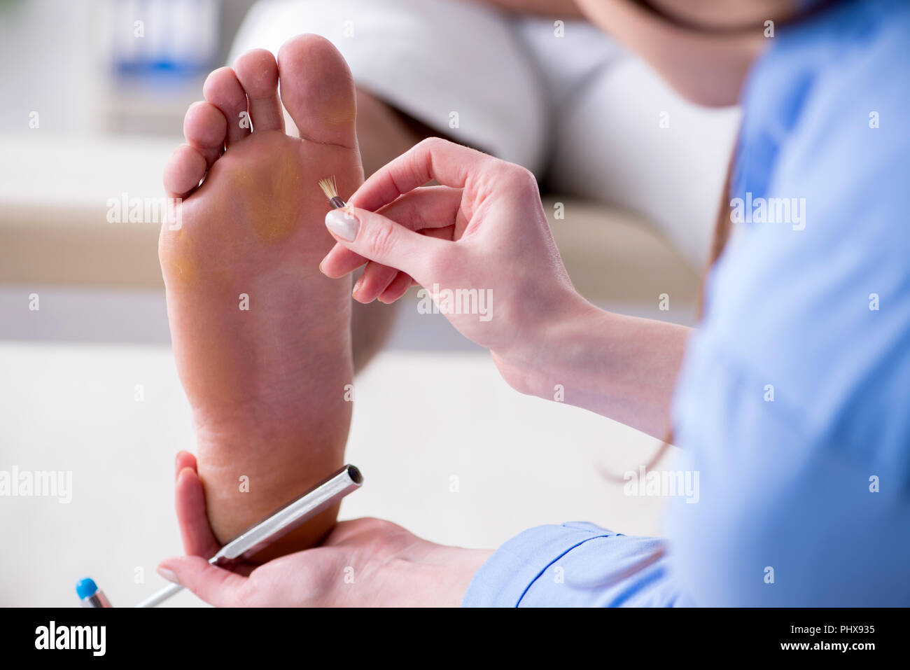Doctor checking nerve reflexes with hammer Stock Photo - Alamy