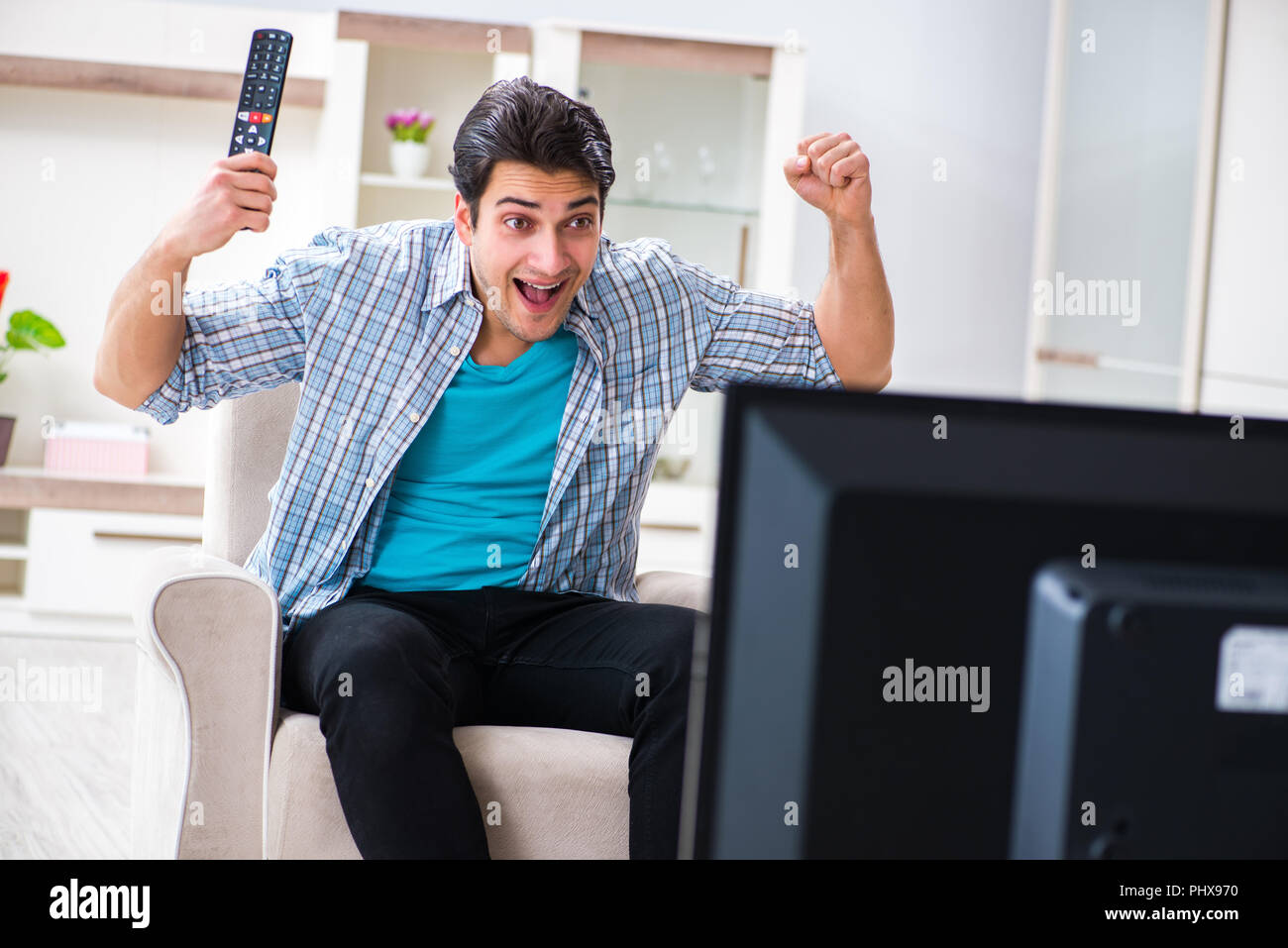Man watching tv reacting hi-res stock photography and images - Alamy