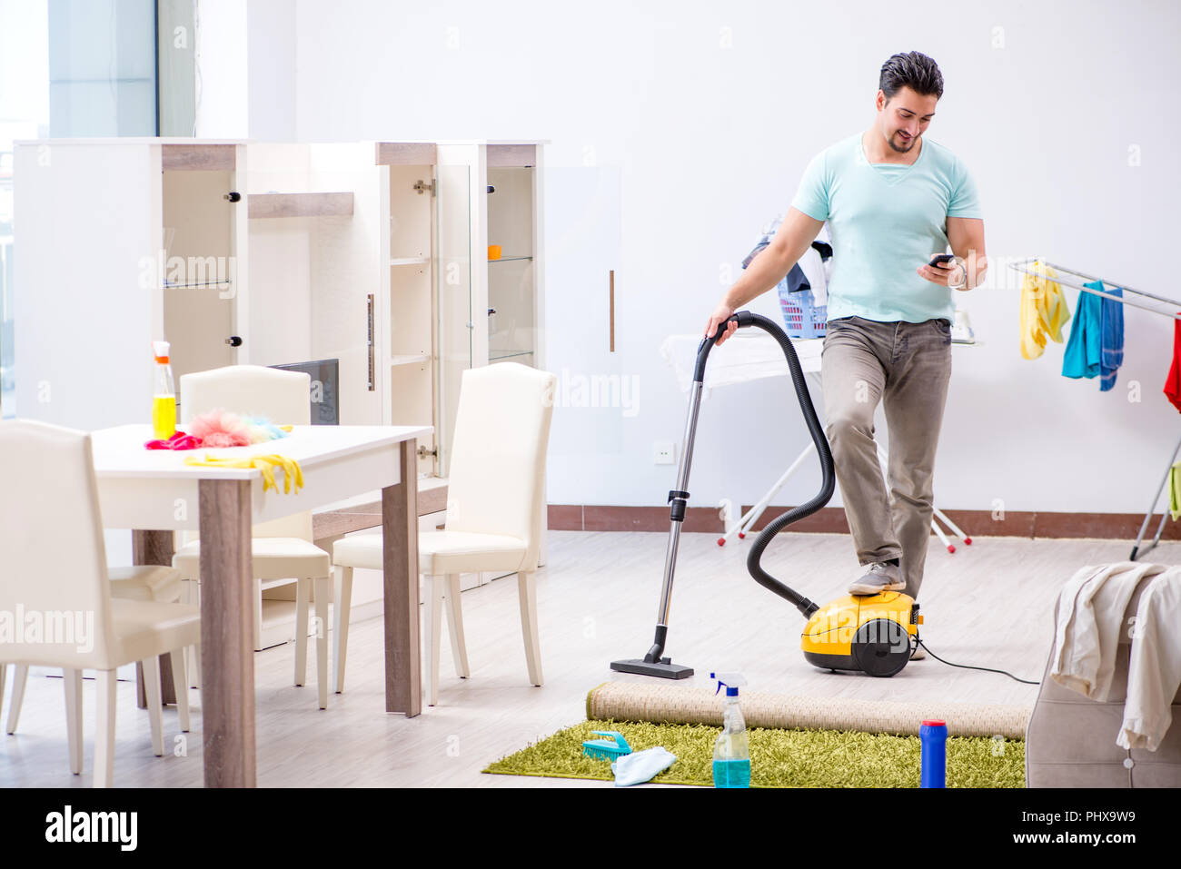 Young man husband doing vacuuming at home Stock Photo - Alamy