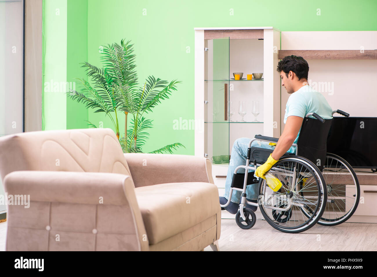 Disabled man on wheelchair cleaning house Stock Photo - Alamy
