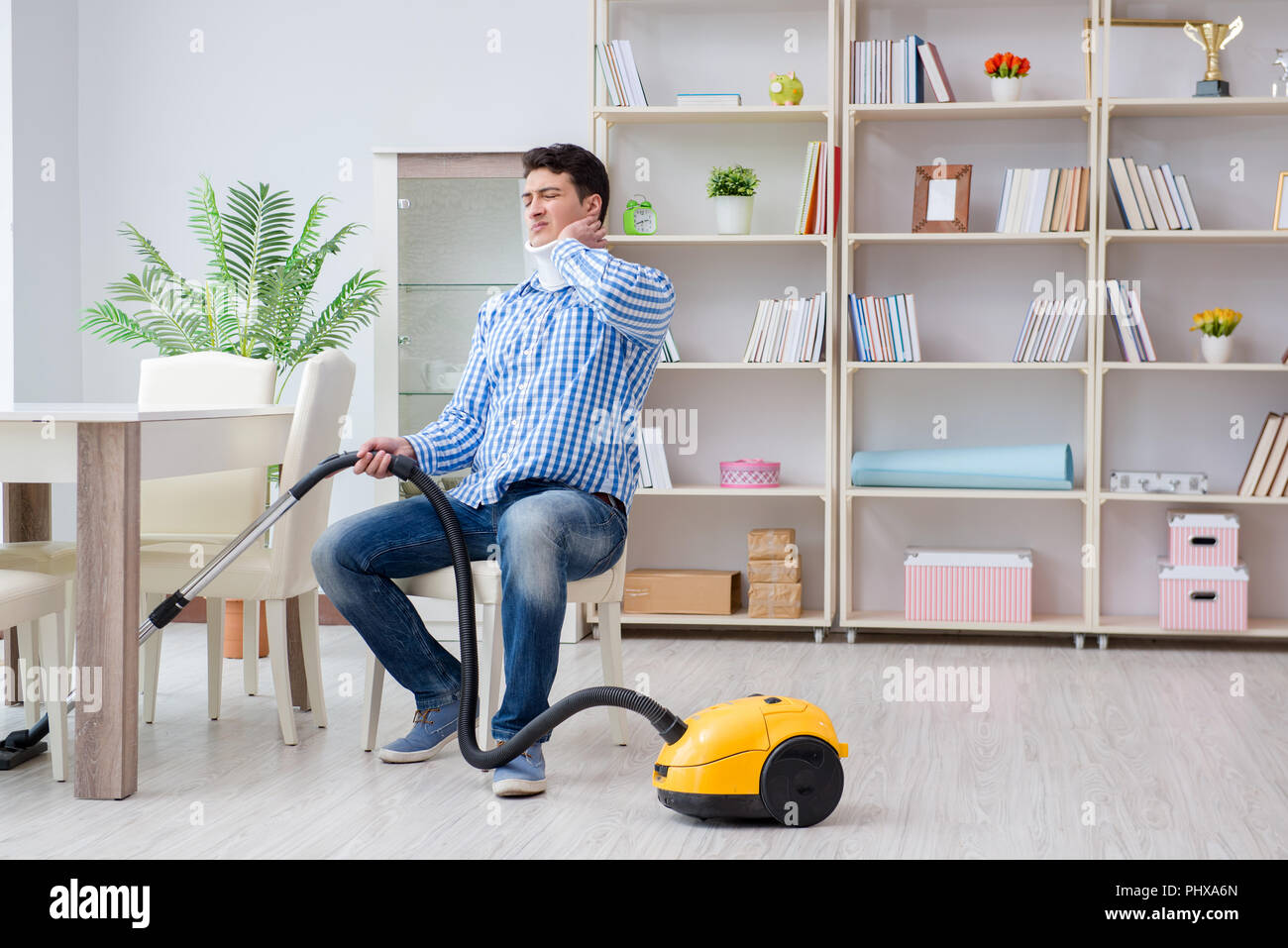 Injured man with neck injury vacuum cleaning house Stock Photo - Alamy