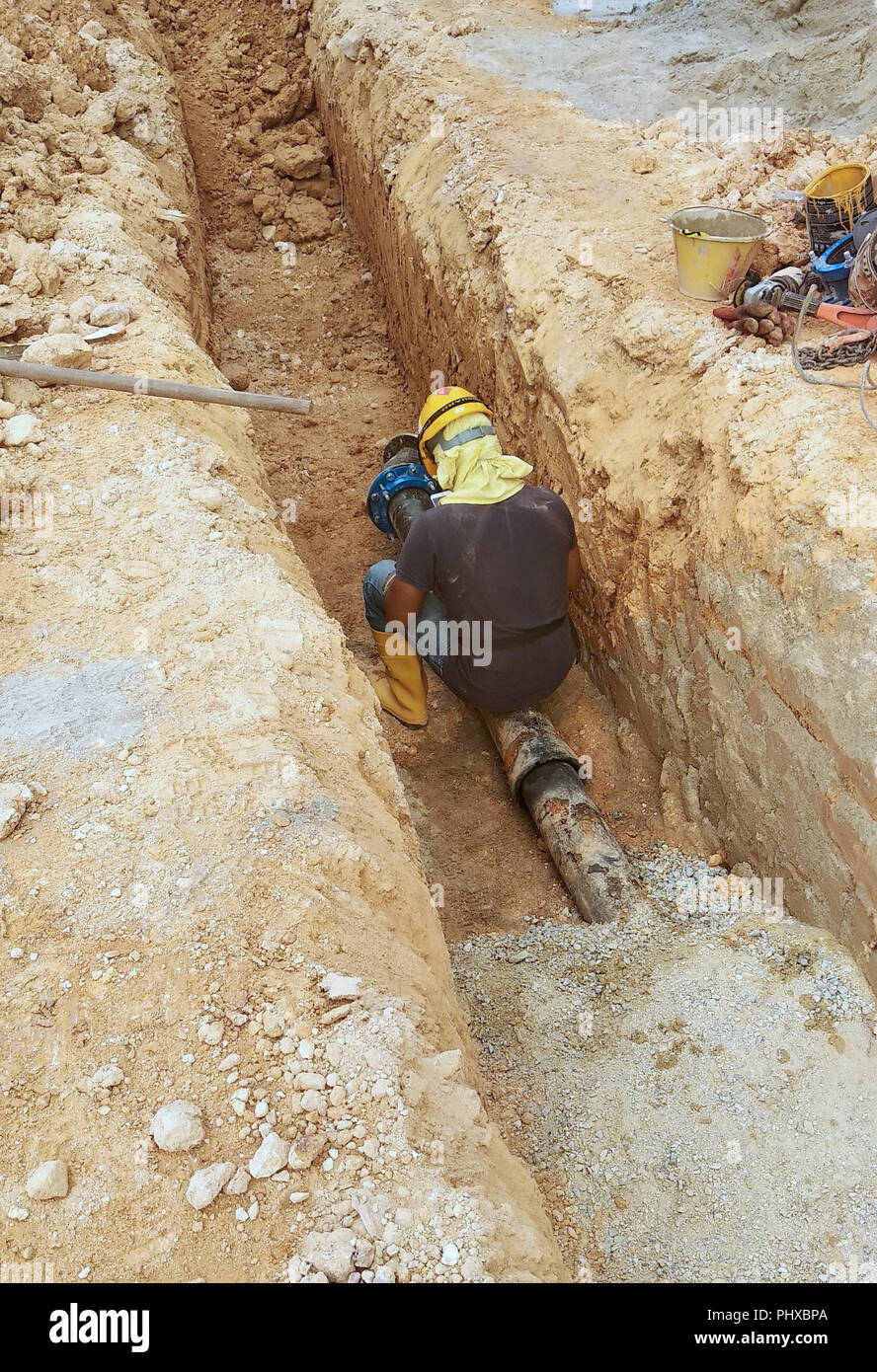 Underground utility and services pipe laid by workers in the trenches ...