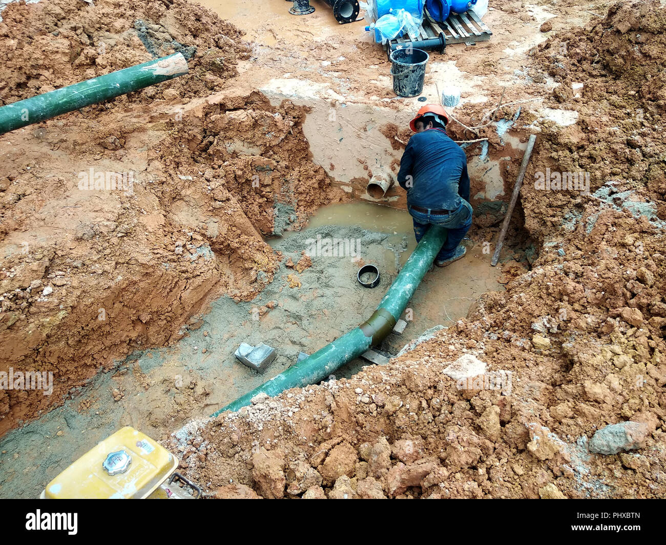 Underground utility and services pipe laid by workers in the trenches ...