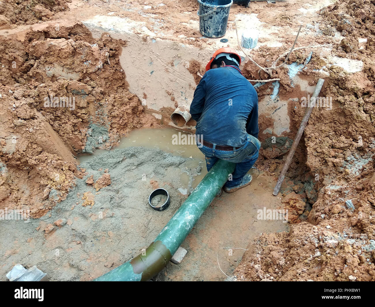 Underground utility and services pipe laid by workers in the trenches ...