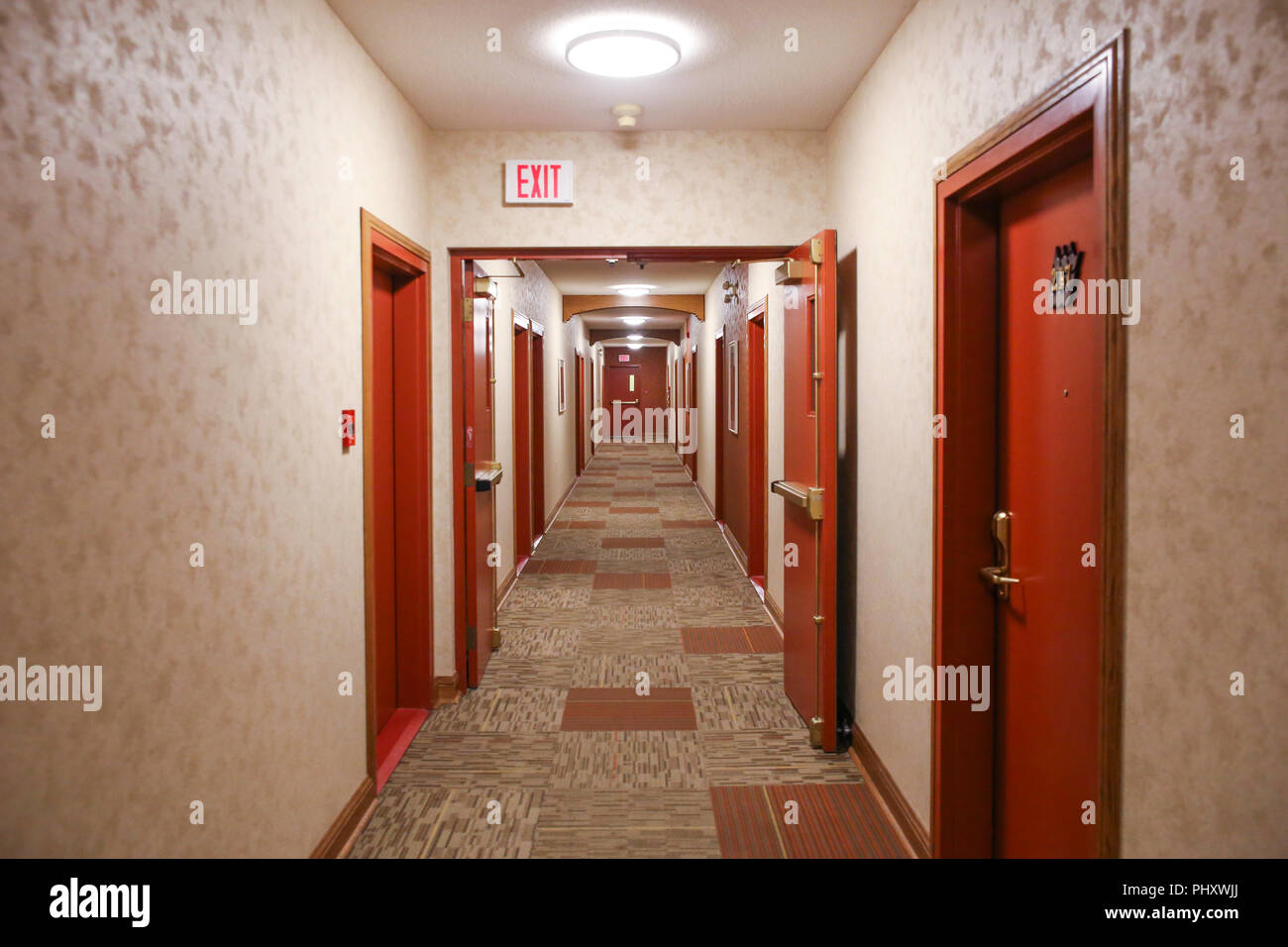 Minimalist hotel corridor. Red doors and grey and red carpete Stock ...