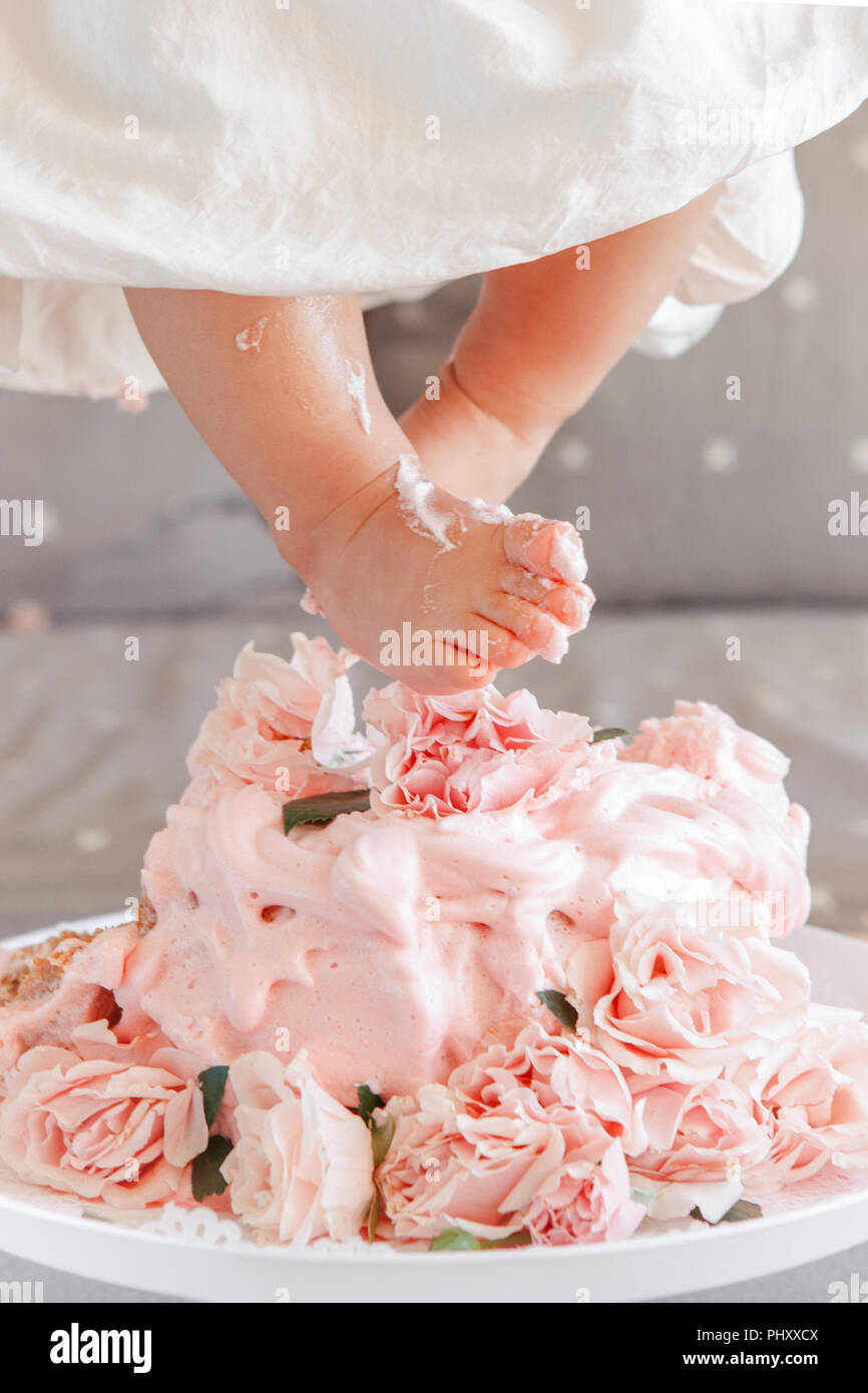 Closeup shot image of baby girl legs feet stepping in cake during her ...