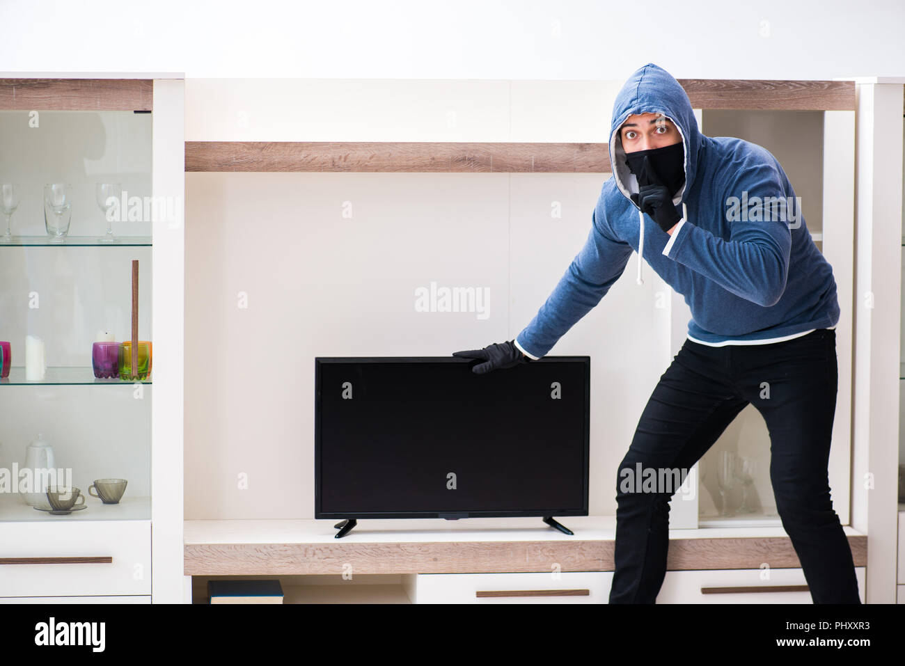 Man burglar stealing tv set from house Stock Photo - Alamy