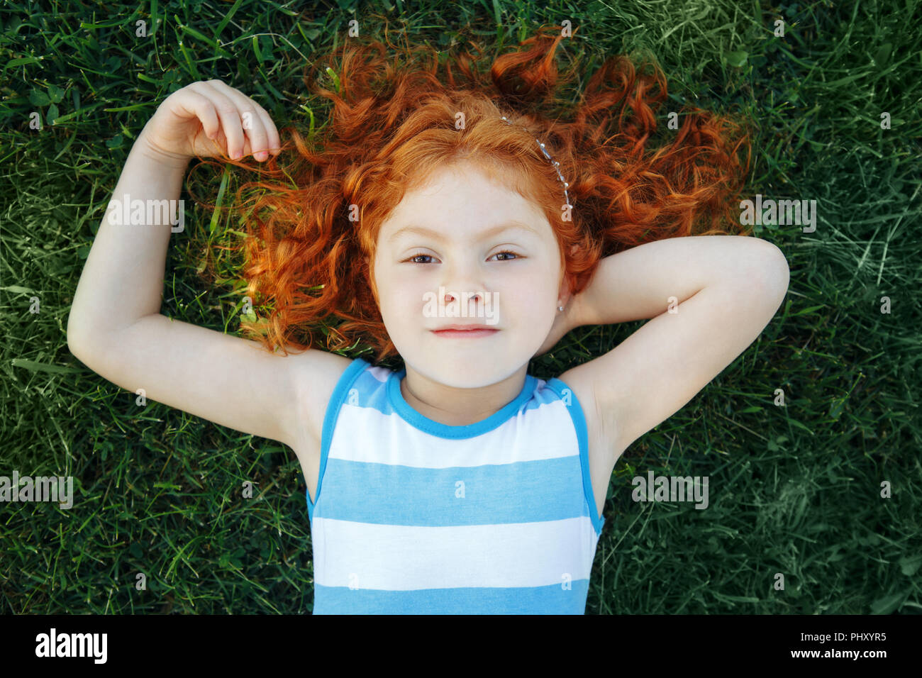 Portrait of cute adorable pensive little red-haired Caucasian girl ...