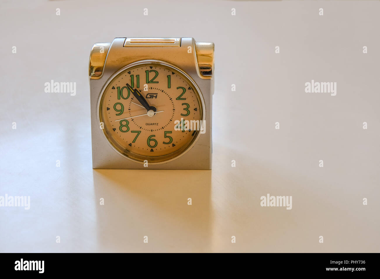 Antique alarm clock on a plain background. Luminous numbers and classic ...