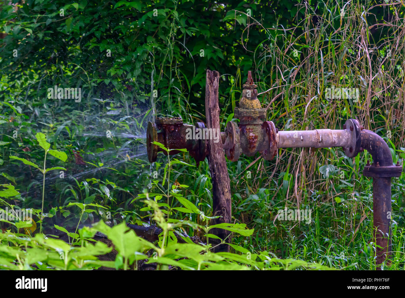 Old iron Metallic water pipe leaking. Rusty burst pipe spraying water ...