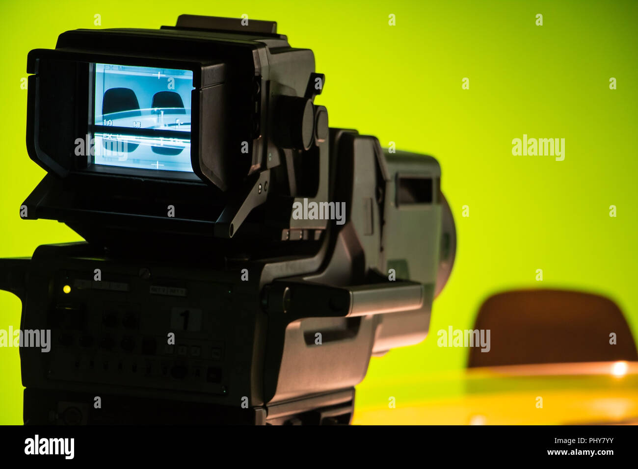 TV studio with professional camera aiming at empty seat, focus on ...