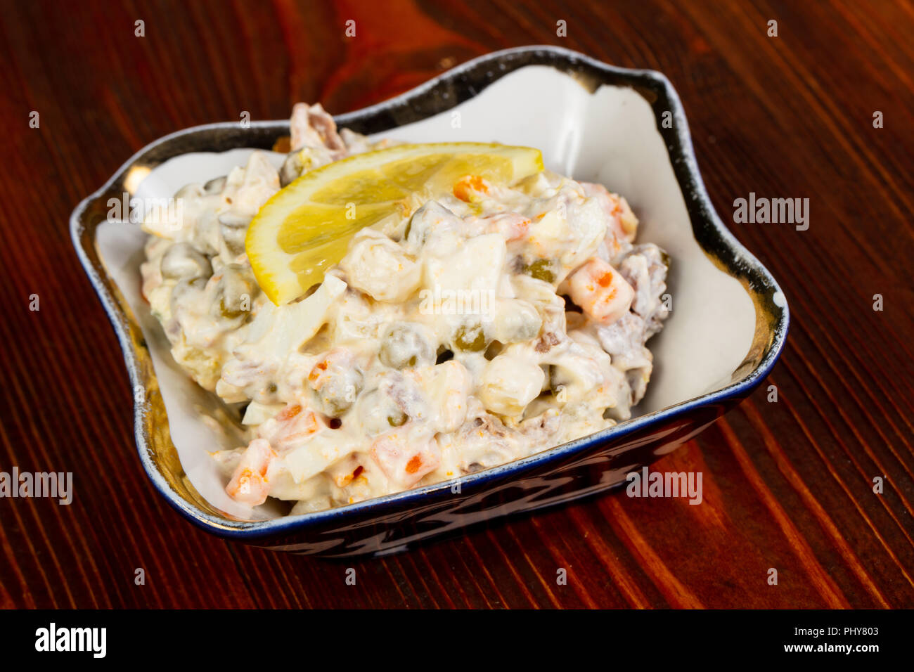 Traditional Russian salad served lemon Stock Photo - Alamy