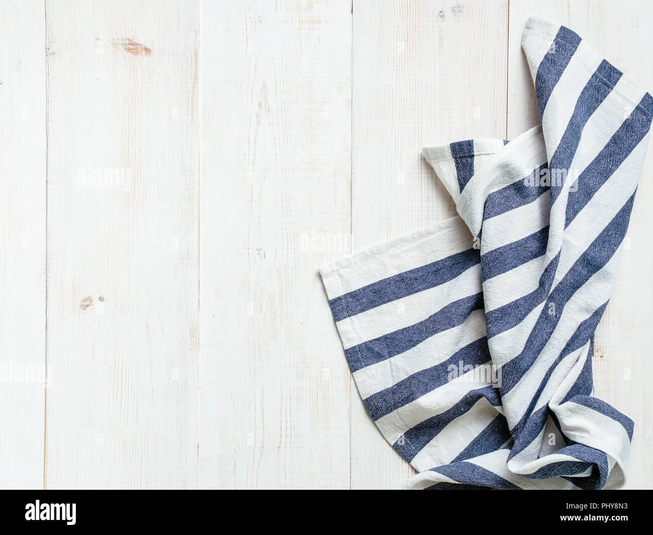 View from above on white wooden table with linen kitchen towel or ...