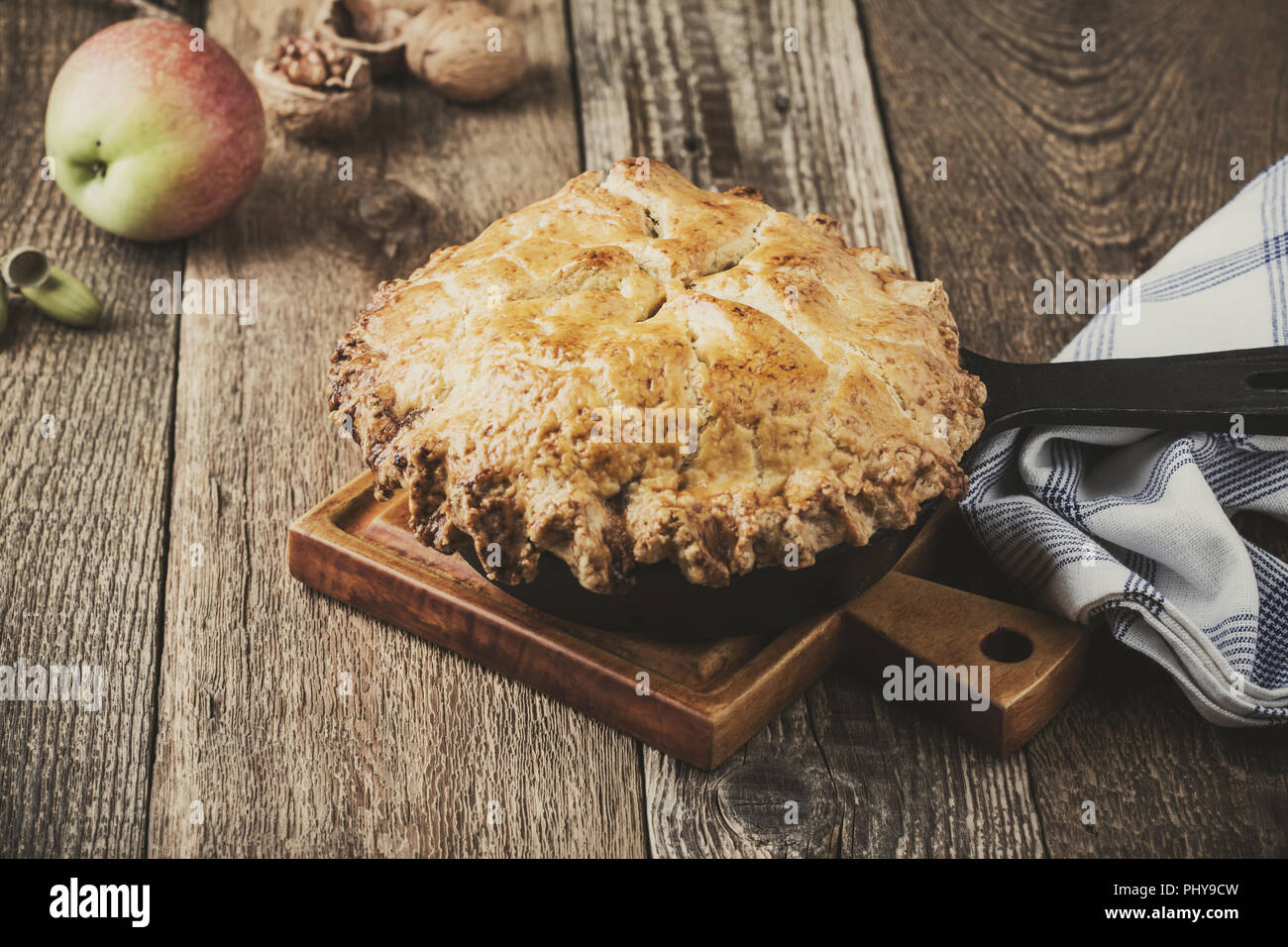 Apple pie in cast iron skillet on rustic wooden table, traditional ...