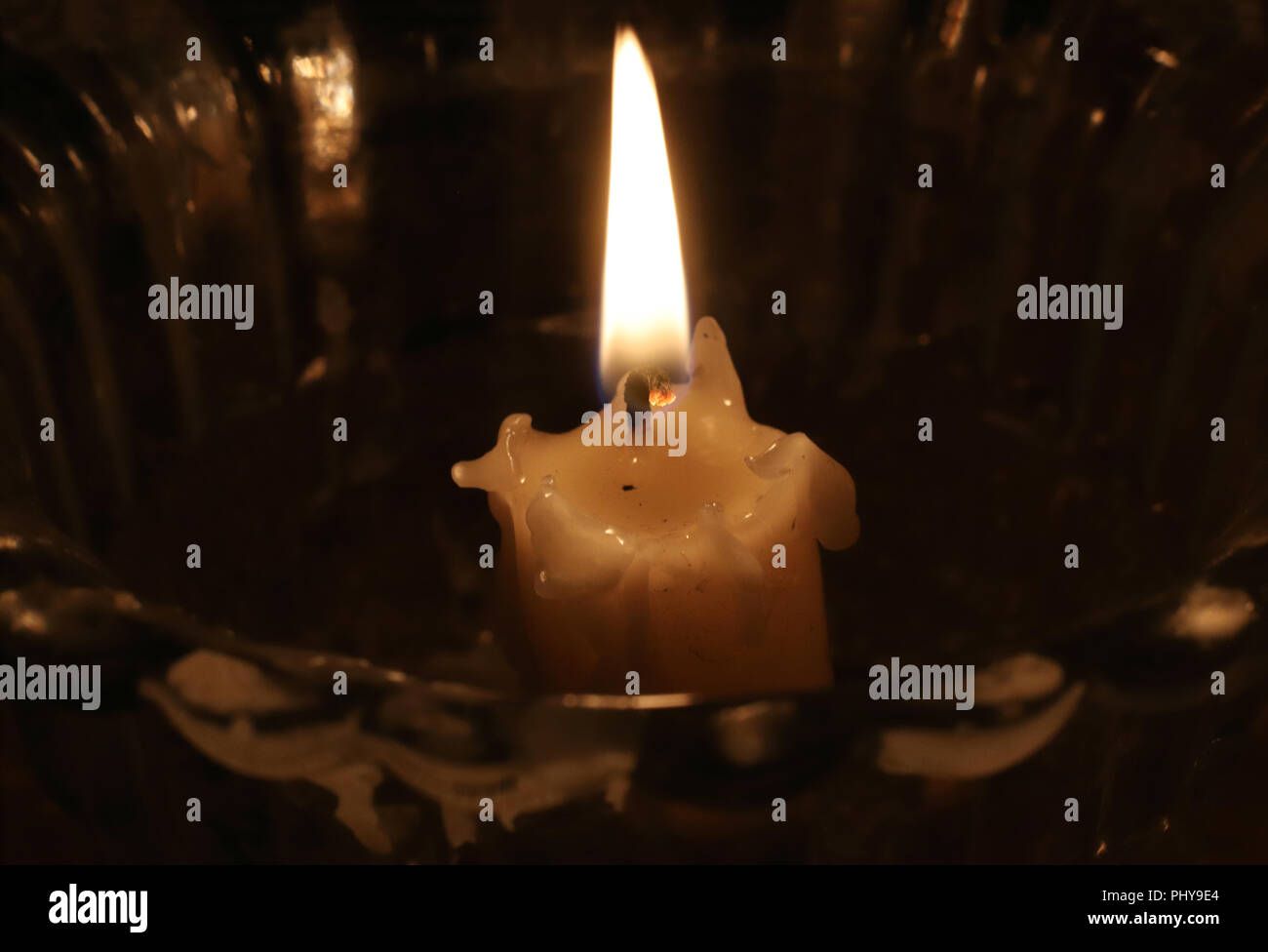 Close up of burning wax candle in a crystal candlestick. Candle flame ...