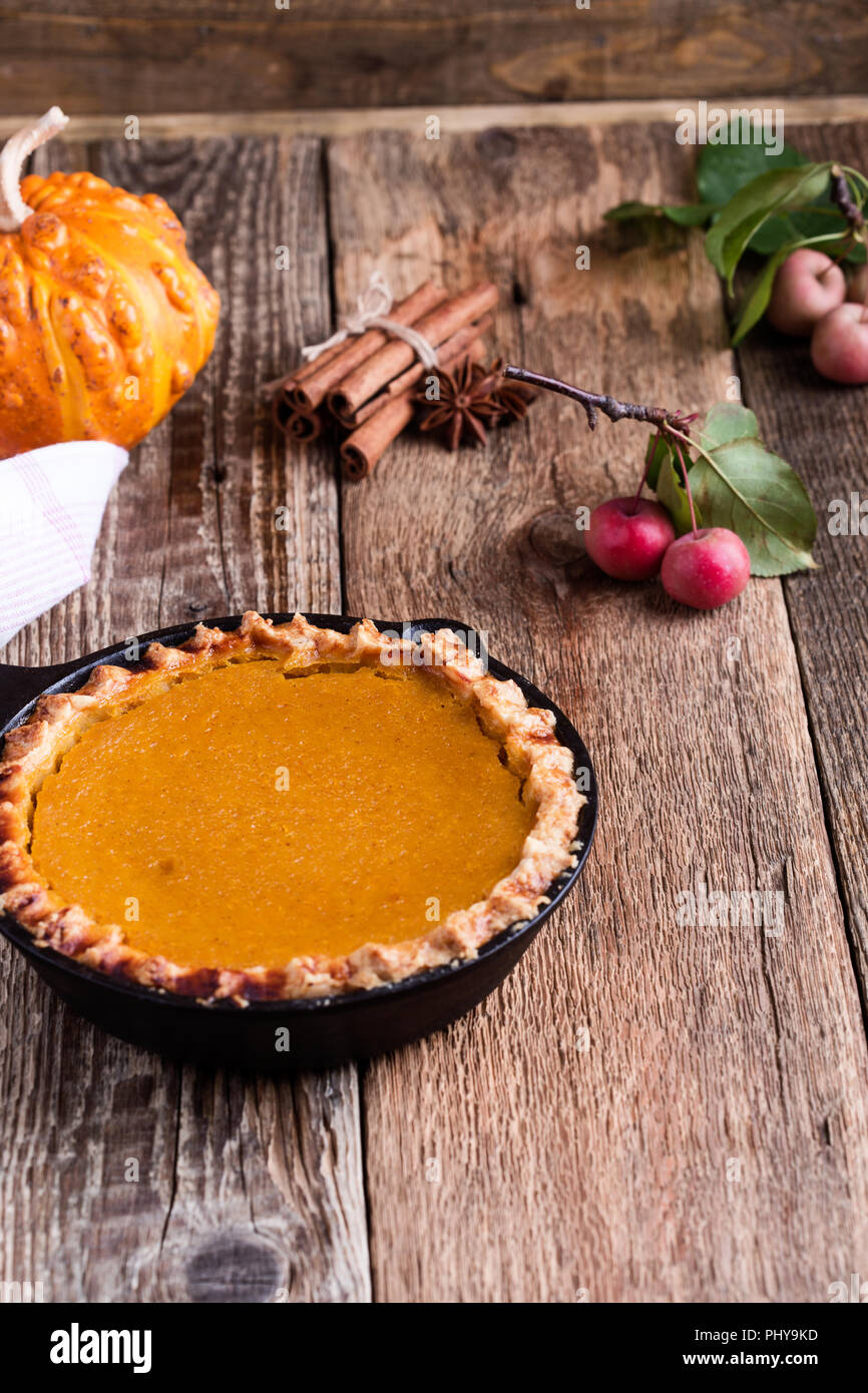 Pumpkin pie in cast iron skillet on wooden table, Thanksgiving Day ...