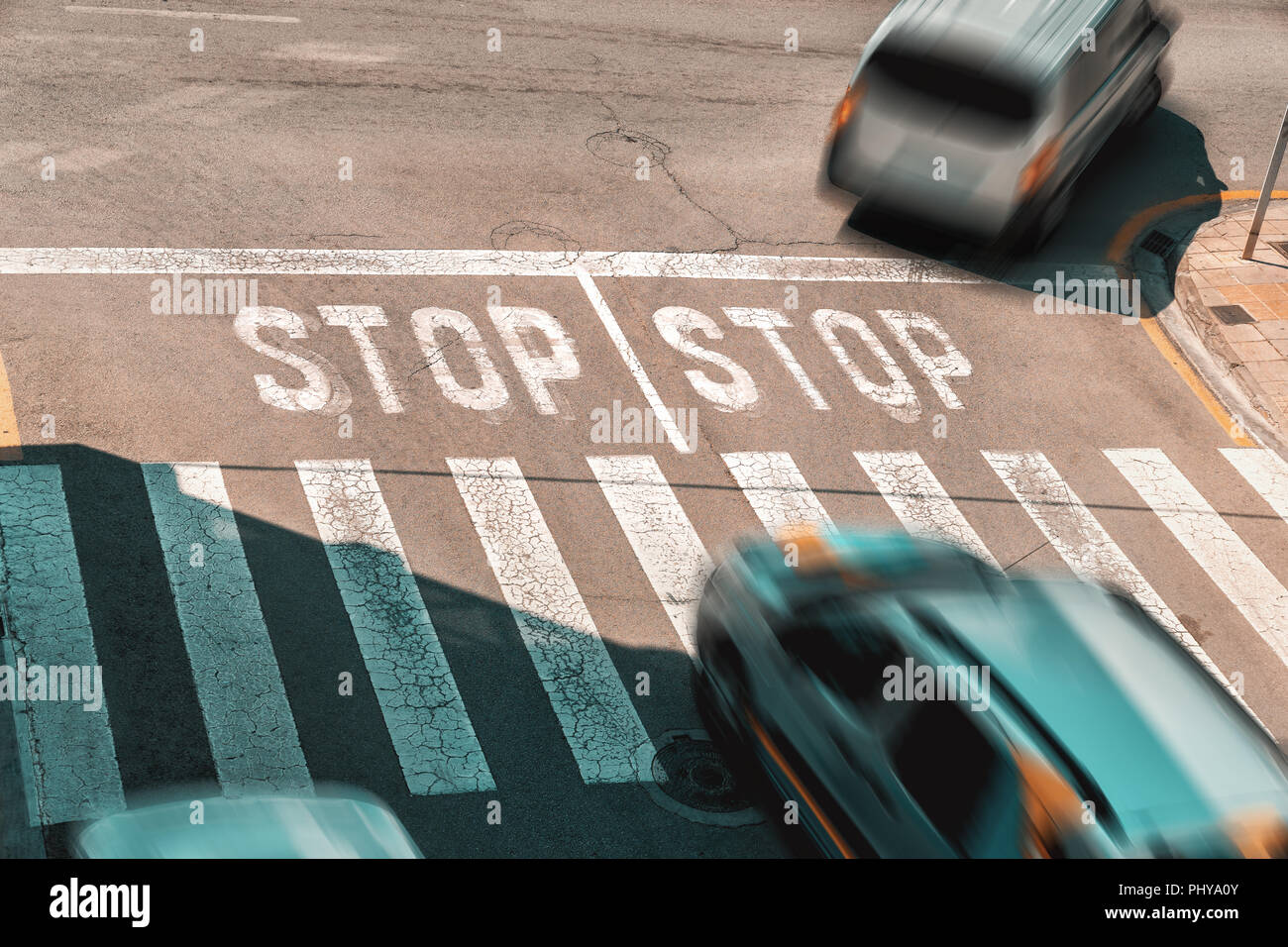 stop sign and zebra crossing on a road with moving cars in motion ...