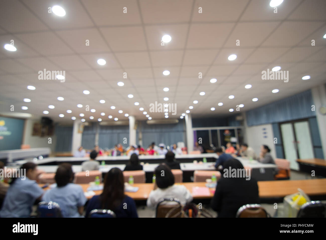 Abstract blurred conference room or seminar room with attendee ...