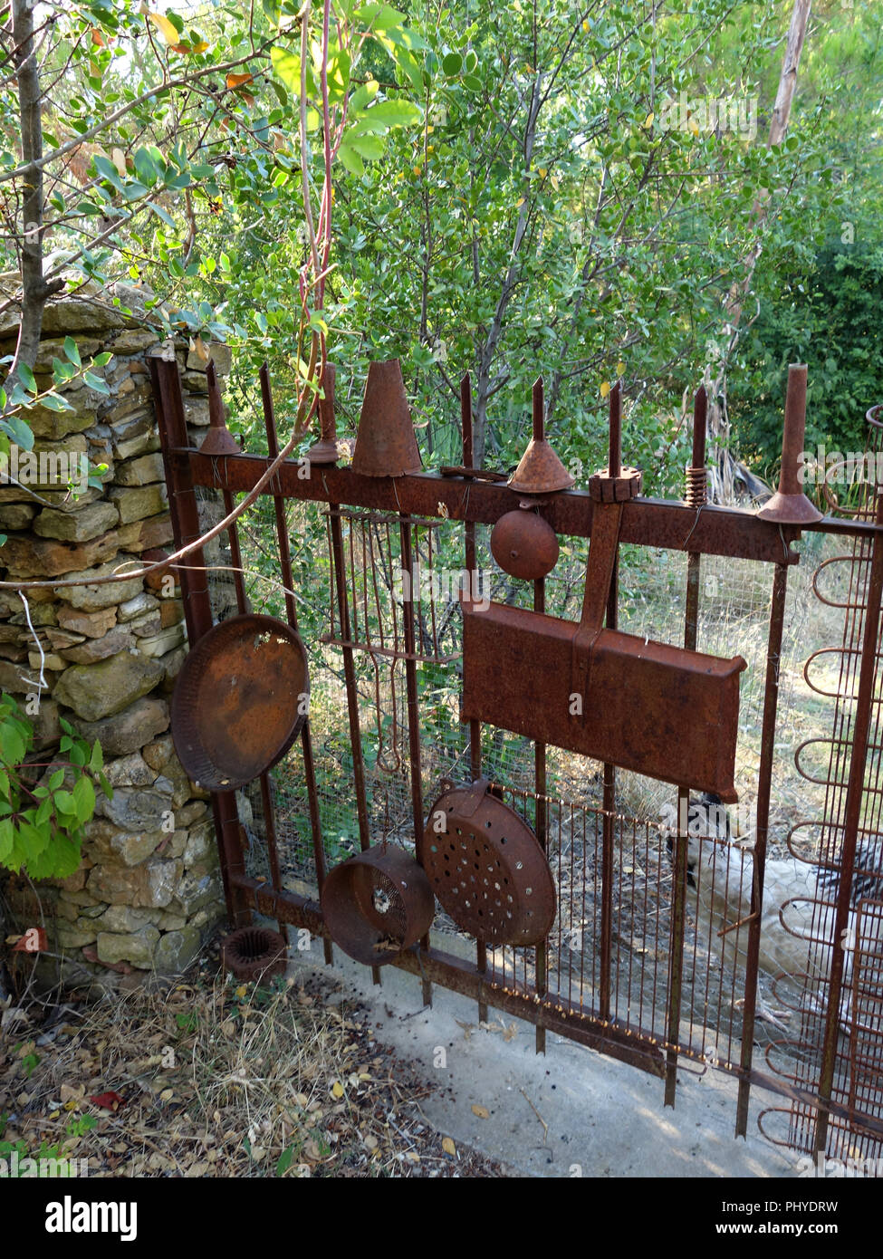 Quirky hand made gate made from old recycled metal items on land at a ...