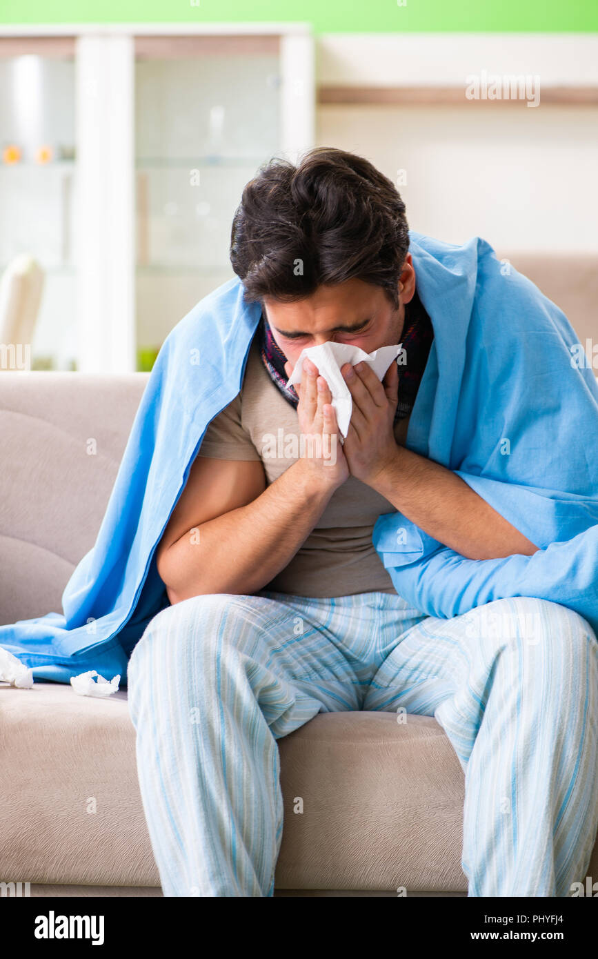 Sick young man suffering from flu at home Stock Photo - Alamy