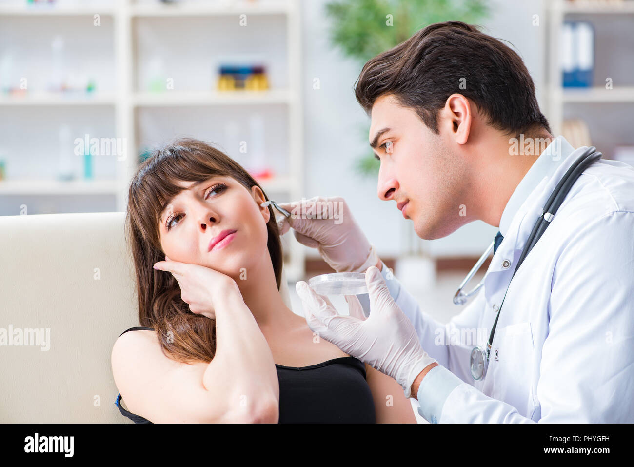 Doctor checking patients ear during medical examination Stock Photo - Alamy