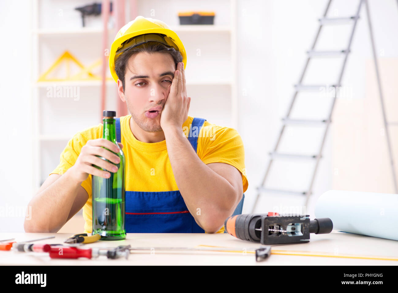 Drunk engineer working in the workshop Stock Photo - Alamy