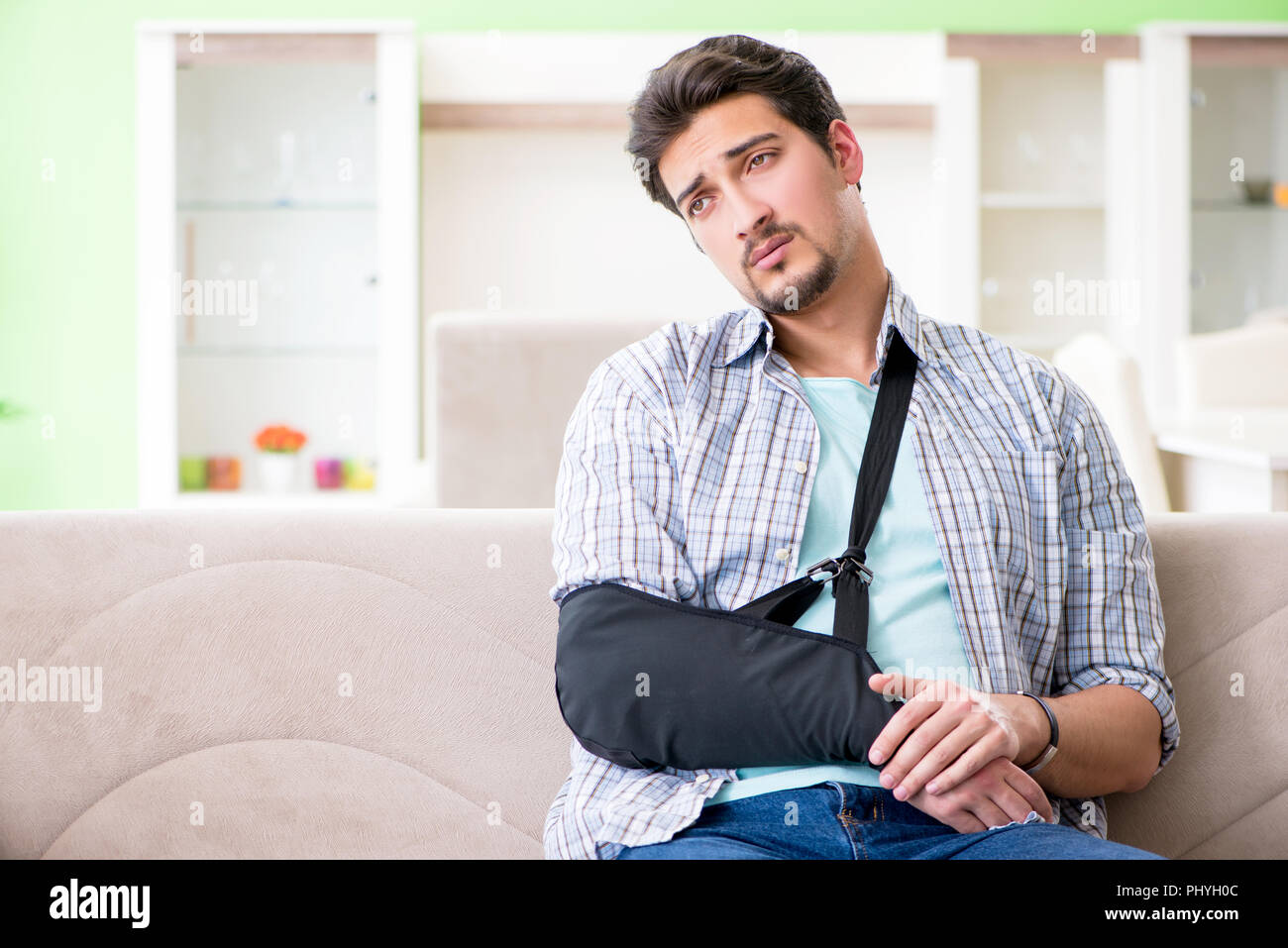 Young student man with hand injury sitting on the sofa Stock Photo - Alamy