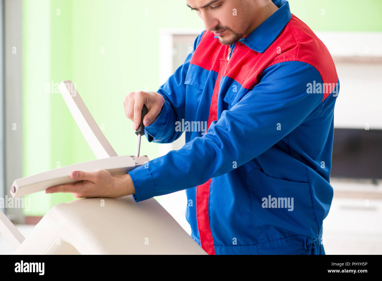 Repair contractor repairing broken chair at home Stock Photo - Alamy