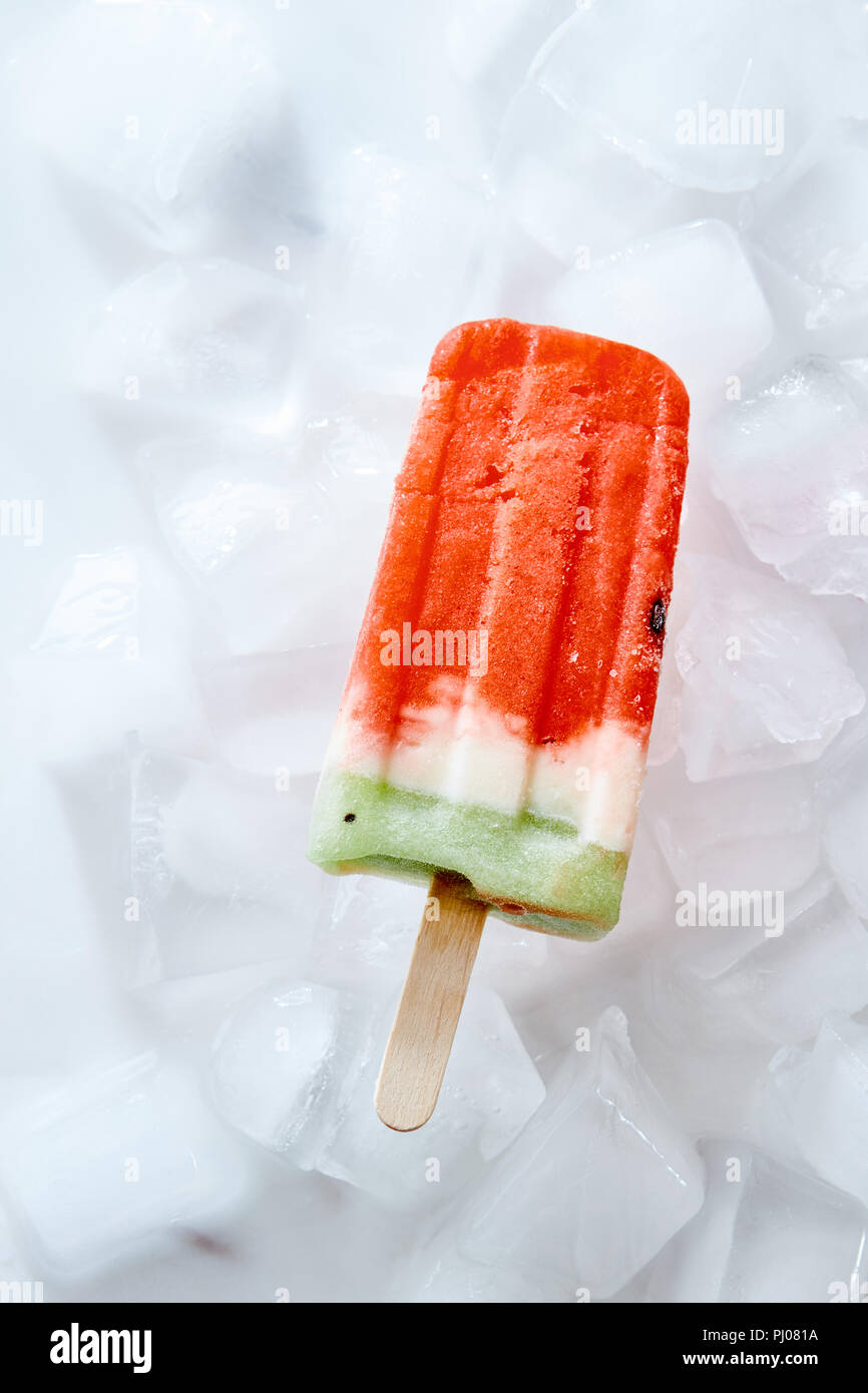 Ice lolly with vanilla smoothie on ice cubes. Homemade cold healthy ...