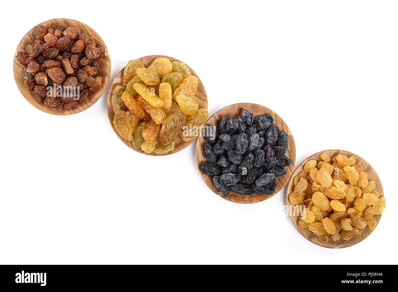 Collection of raisins in wooden bowl isolated on a white background ...