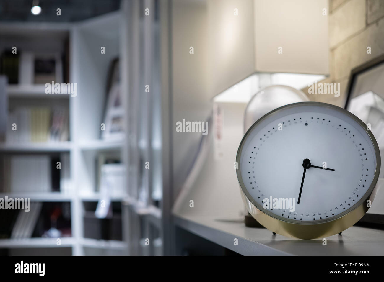 Modern white clock in the living room with book shelves and lamp Stock ...