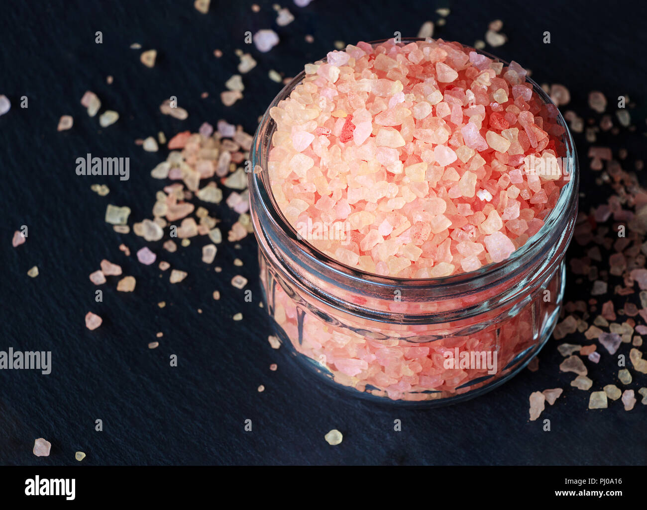 Pink Himalayan salt in jar on dark slate background. Top view. Isolated ...