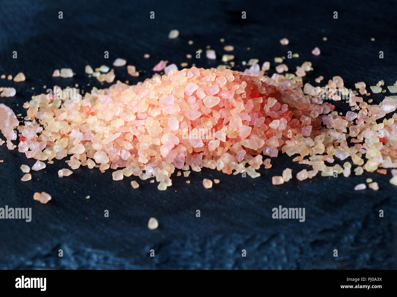 Pile of Pink Himalayan salt in jar on dark slate background. Top view ...