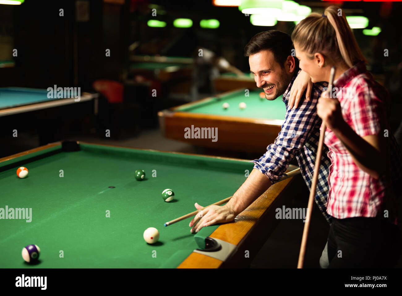 Young couple playing snooker together in bar Stock Photo - Alamy