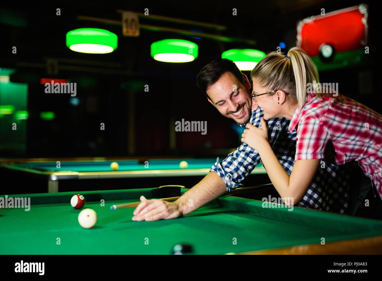 Young couple playing snooker together in bar Stock Photo - Alamy